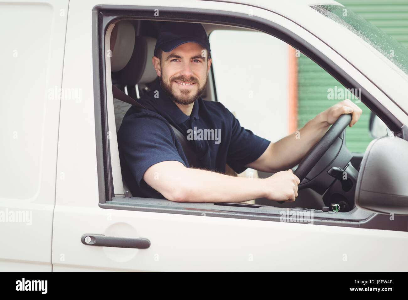 Delivery man driving his van Stock Photo - Alamy