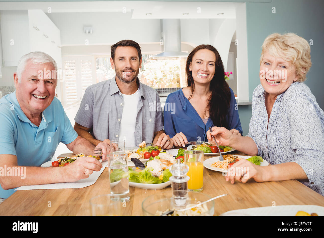 Portrait of family sitting at dining table Stock Photo - Alamy