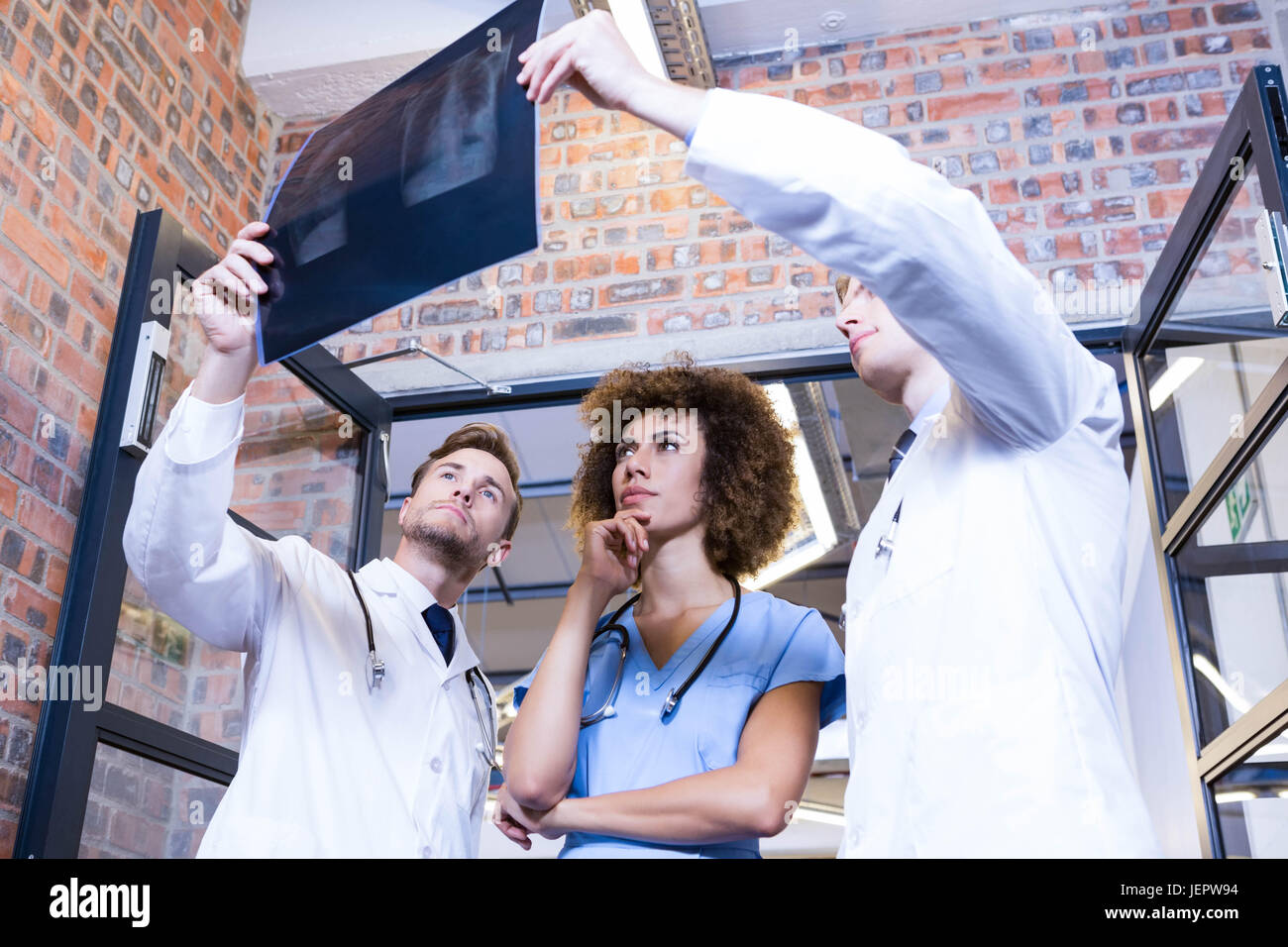 Group of doctors examining a x report Stock Photo - Alamy