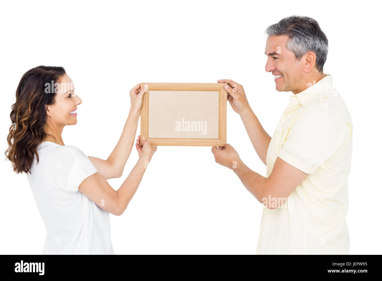 Happy couple holding picture frame Stock Photo - Alamy