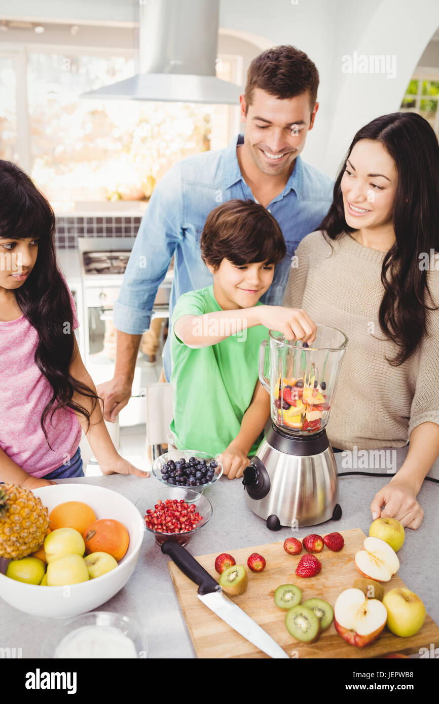 Cheerful family preparing fruit juice Stock Photo - Alamy