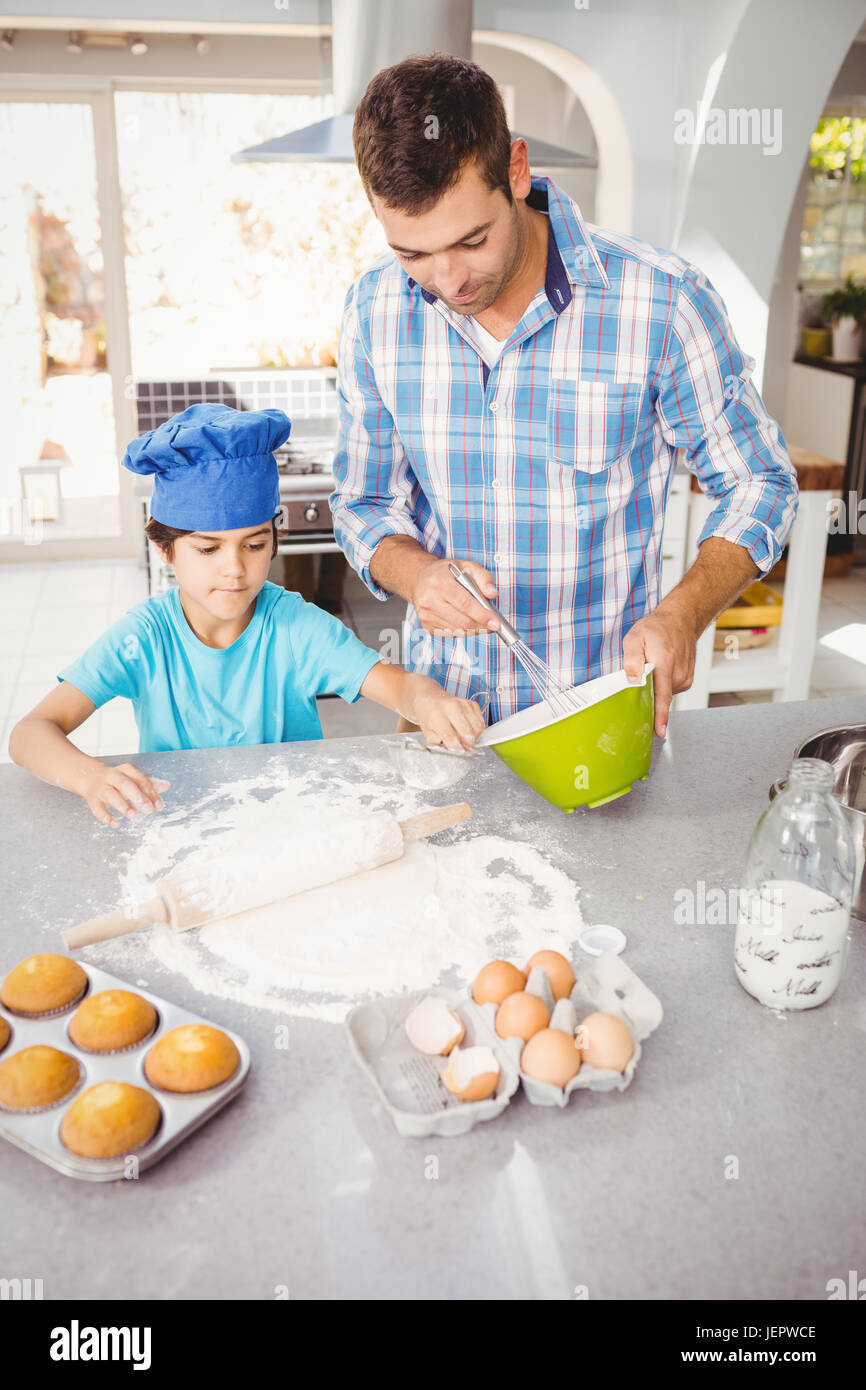 Boy helping father in preparing food Stock Photo - Alamy