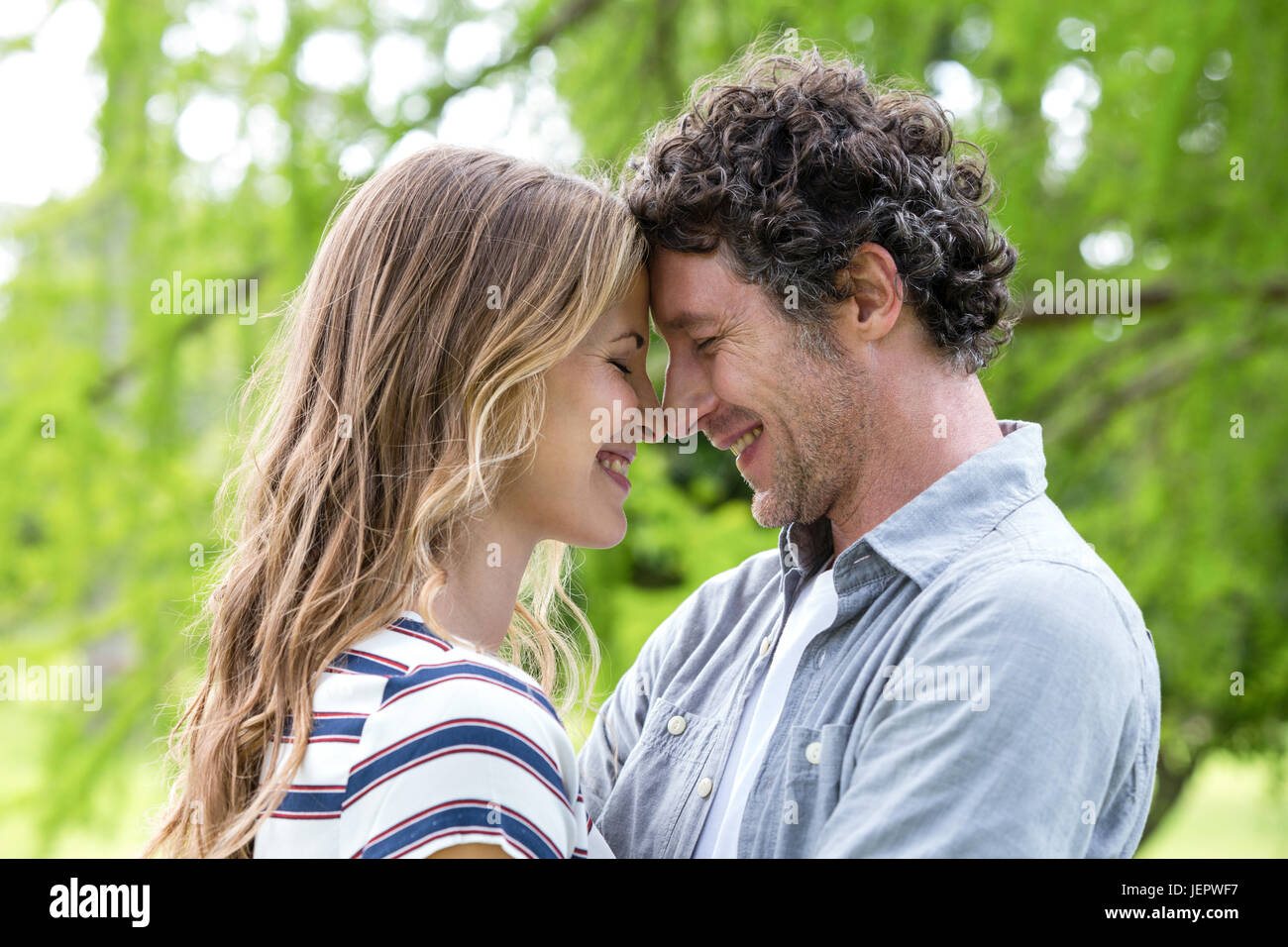 Smiling couple embracing head to head Stock Photo - Alamy
