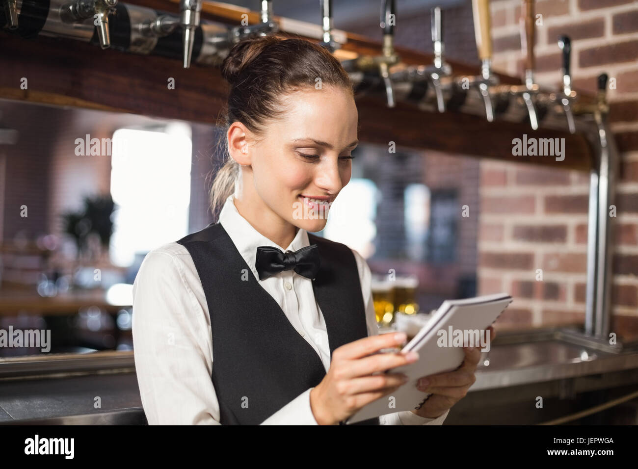 Barmaid taking orders on notepad Stock Photo - Alamy