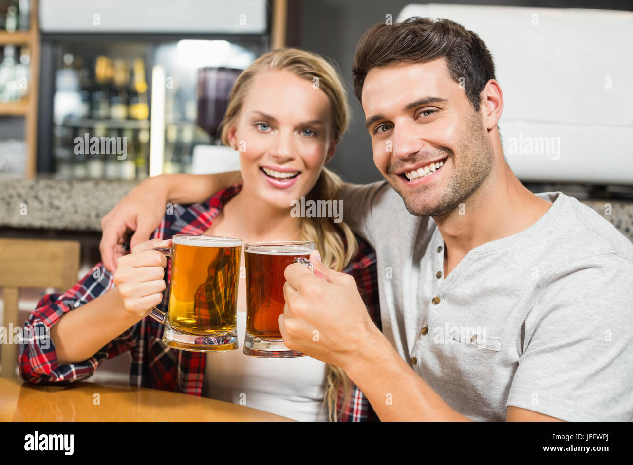 Couple toasting with beers Stock Photo - Alamy