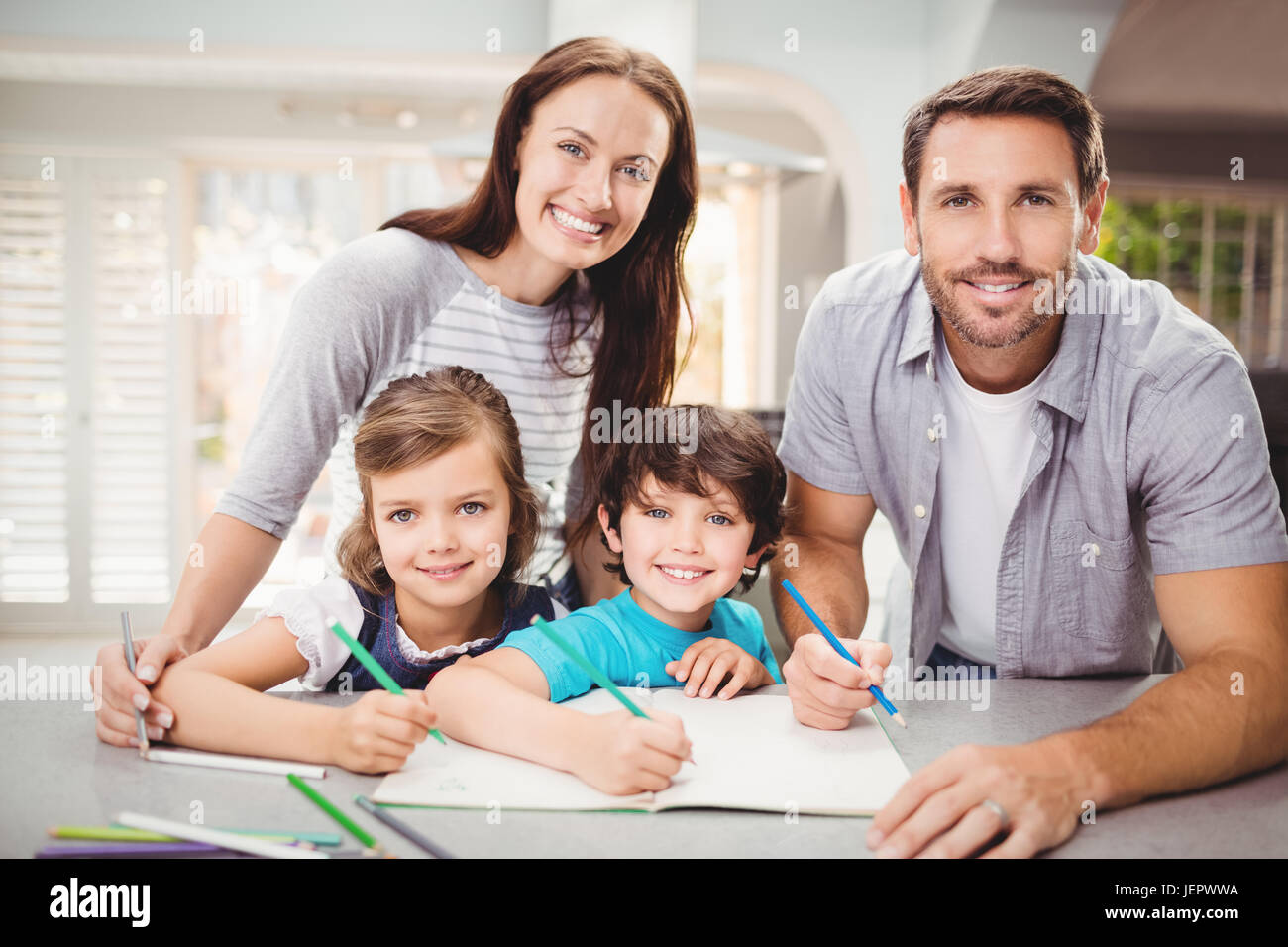 Portrait of smiling family writing in book Stock Photo - Alamy