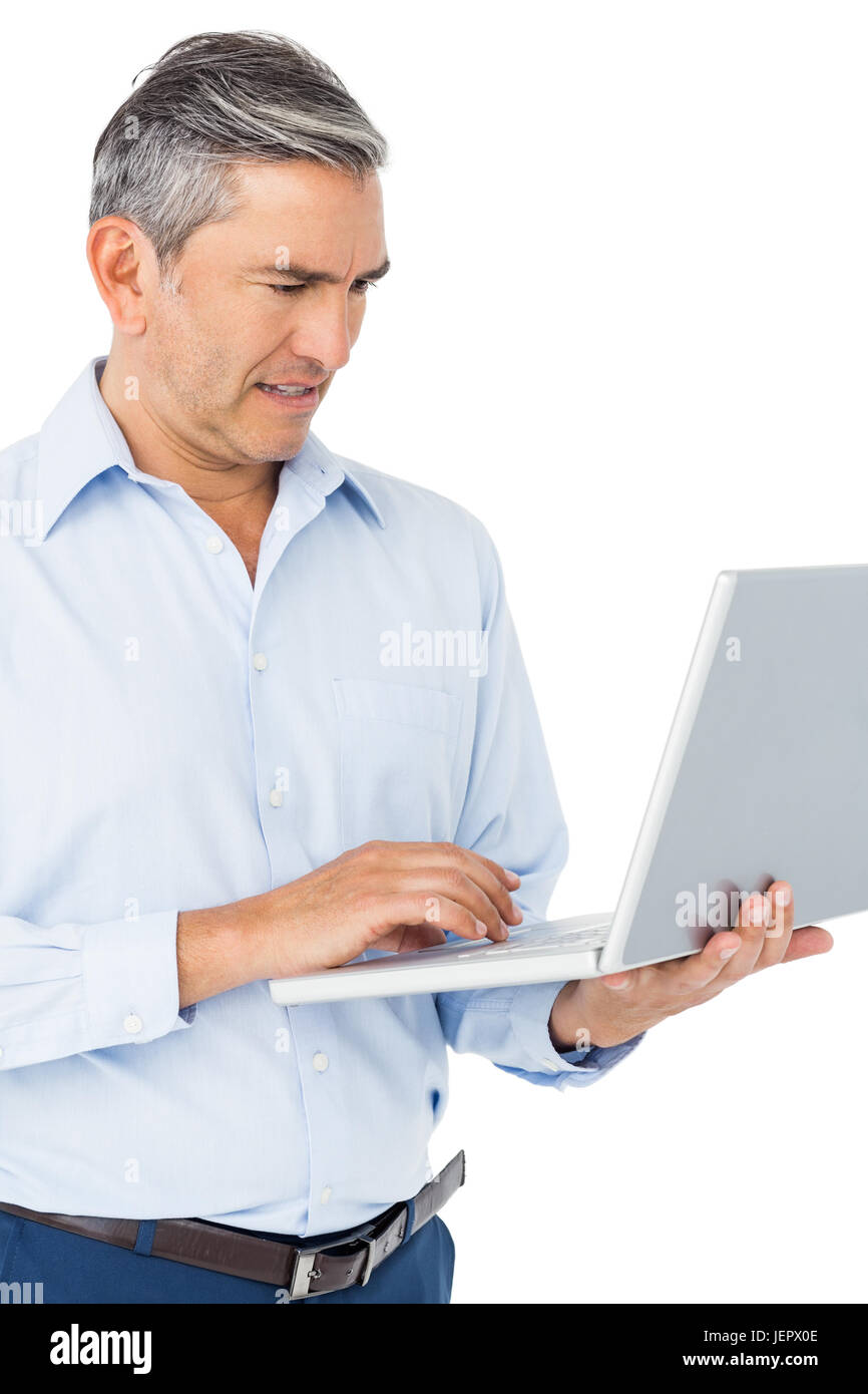 Smiling businessman typing on laptop Stock Photo - Alamy