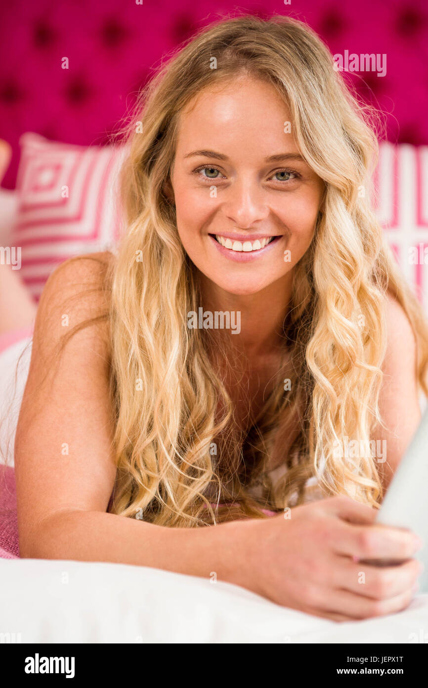 Pretty blonde using tablet lying hi-res stock photography and images ...