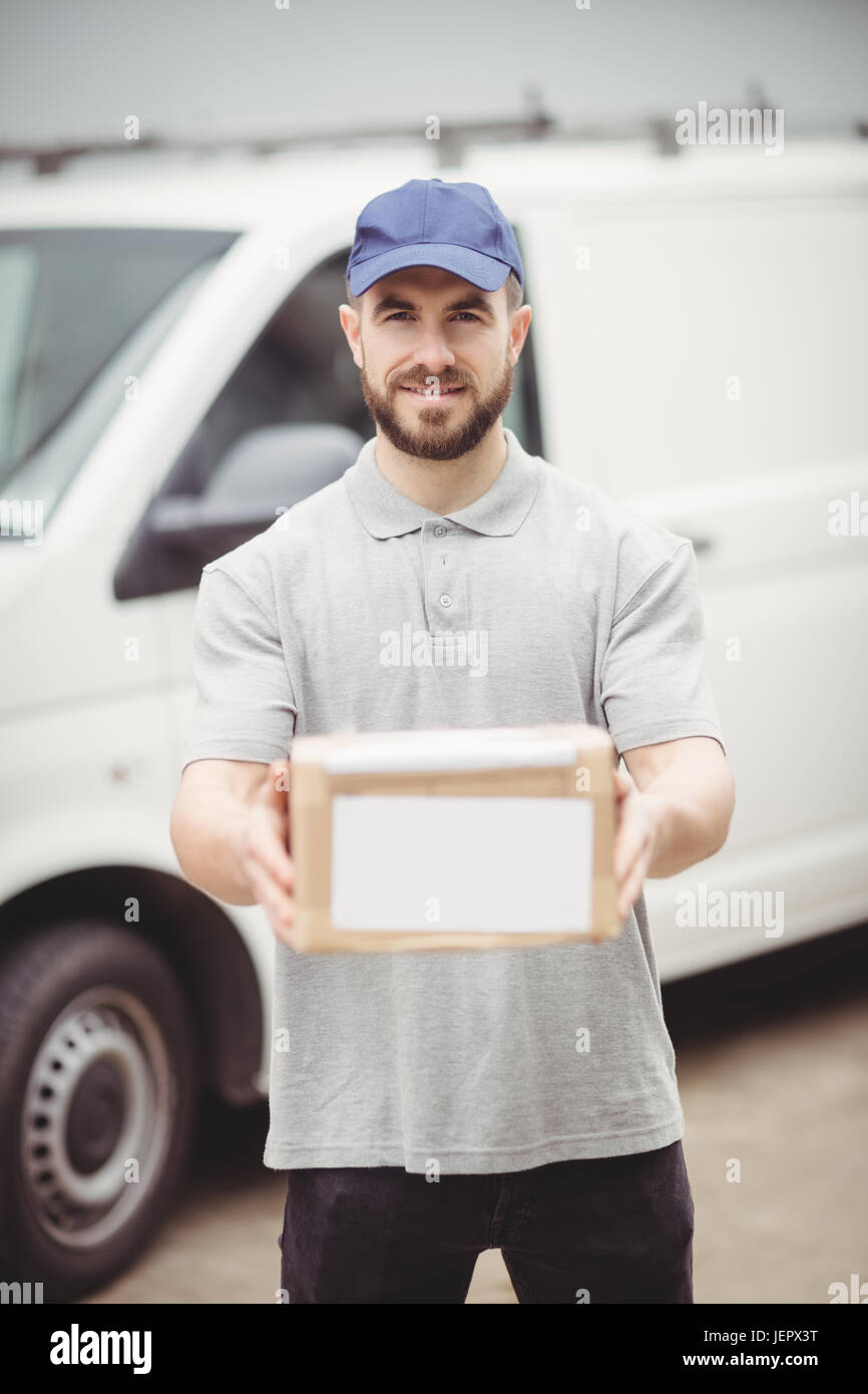 Delivery man holding package Stock Photo - Alamy