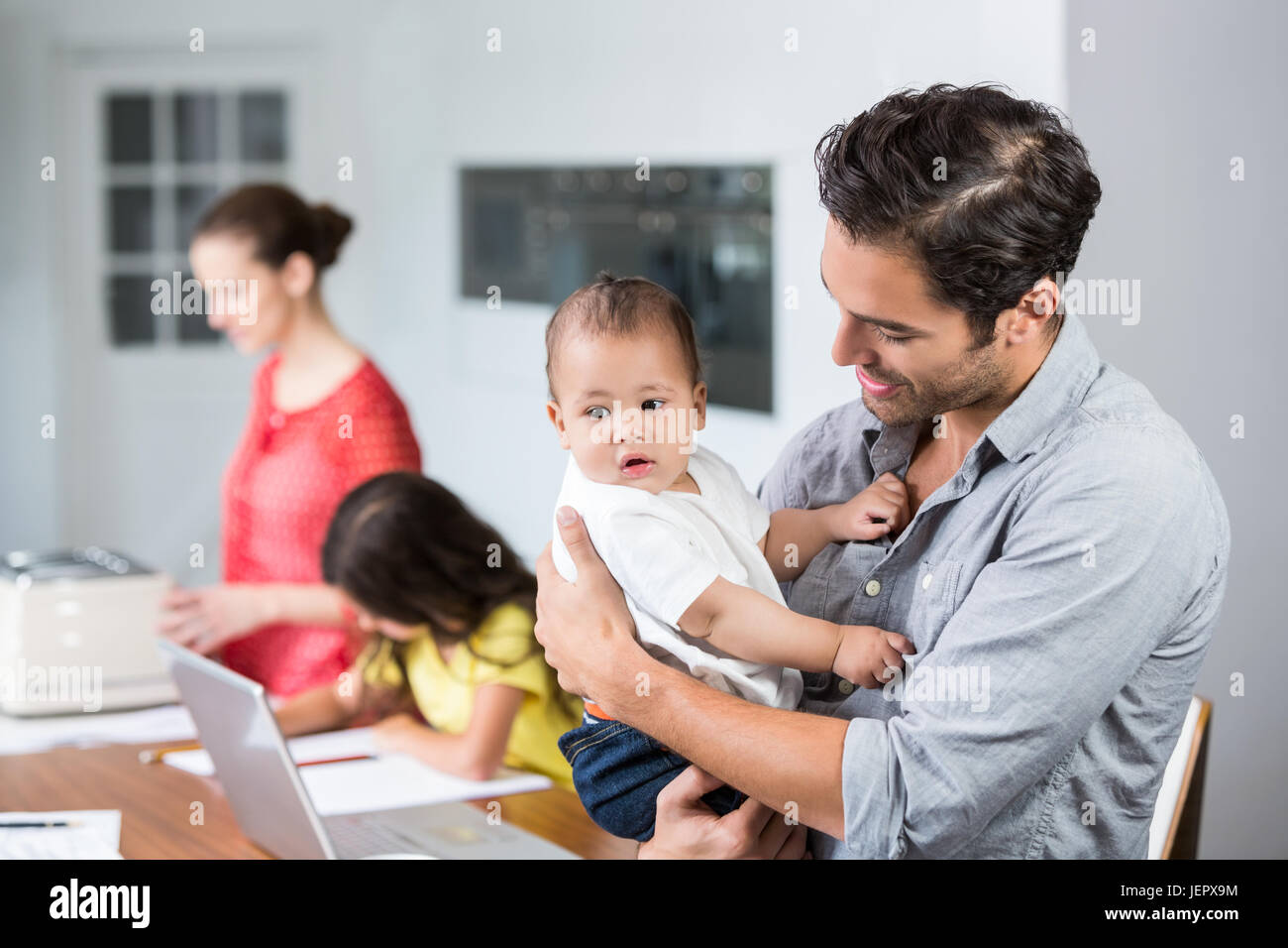 Father carrying baby at home Stock Photo - Alamy