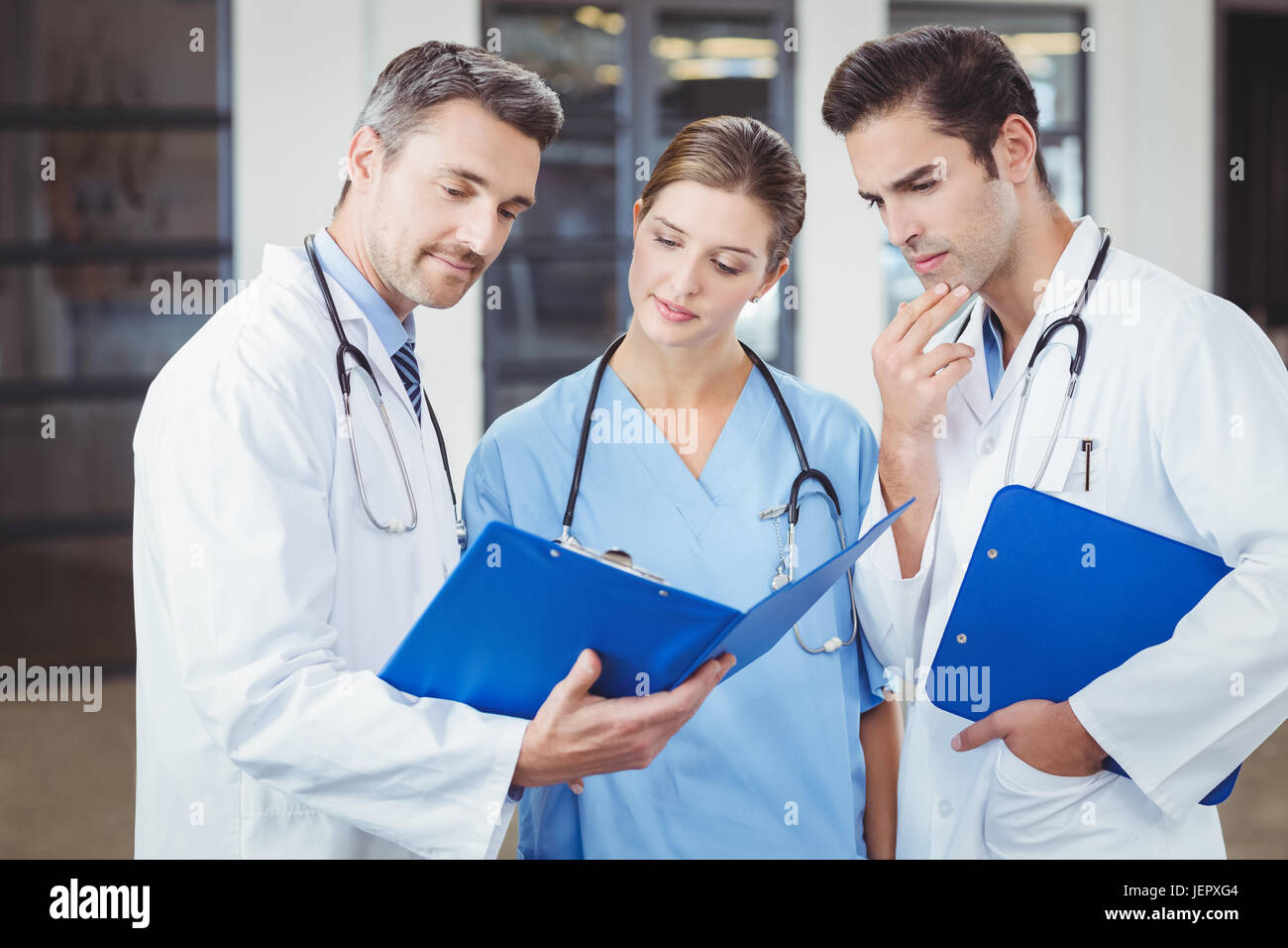 Doctors examining while holding clipboard Stock Photo - Alamy