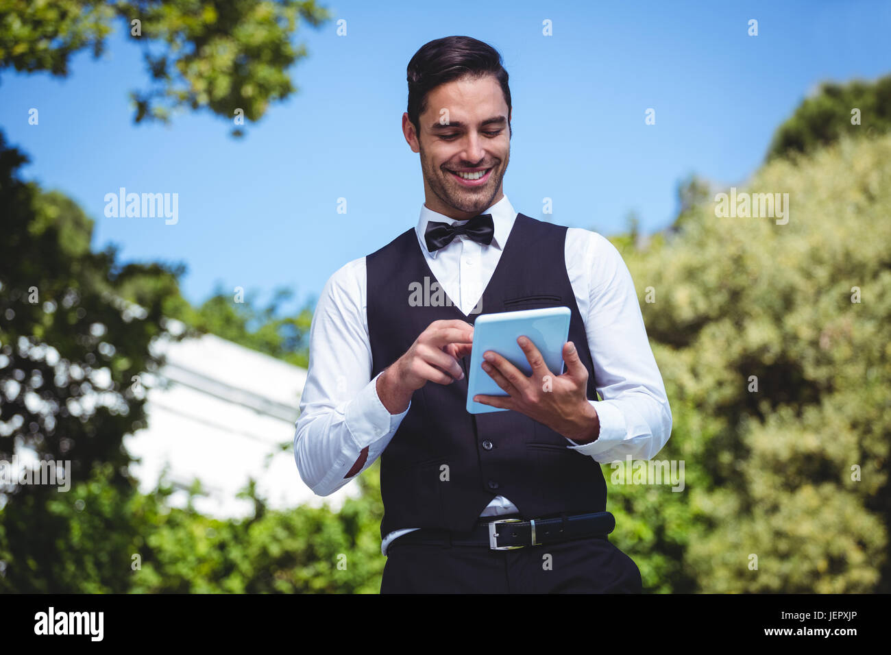 Handsome waiter using tablet computer Stock Photo - Alamy