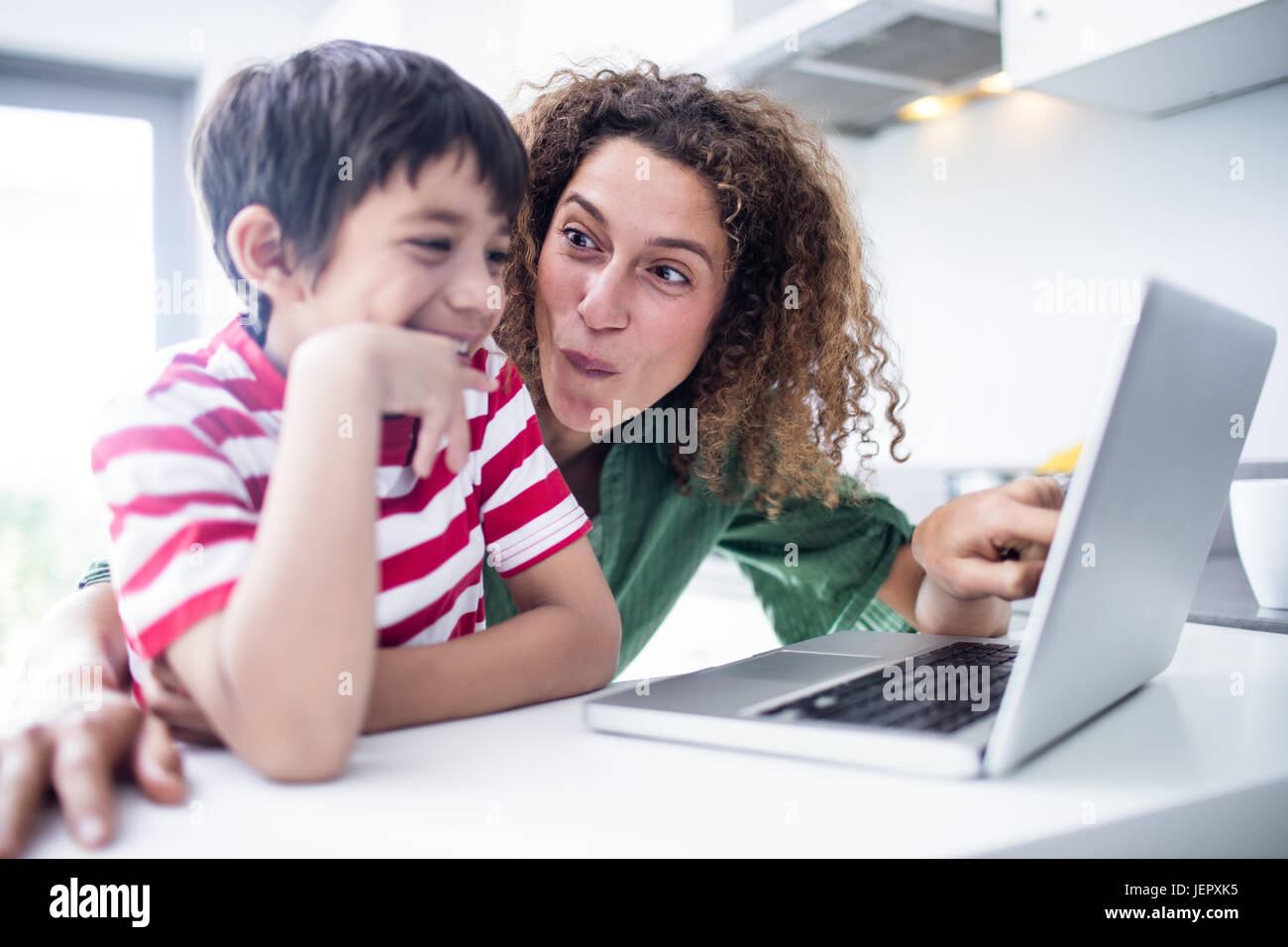 Mother and son using laptop in kitchen Stock Photo - Alamy