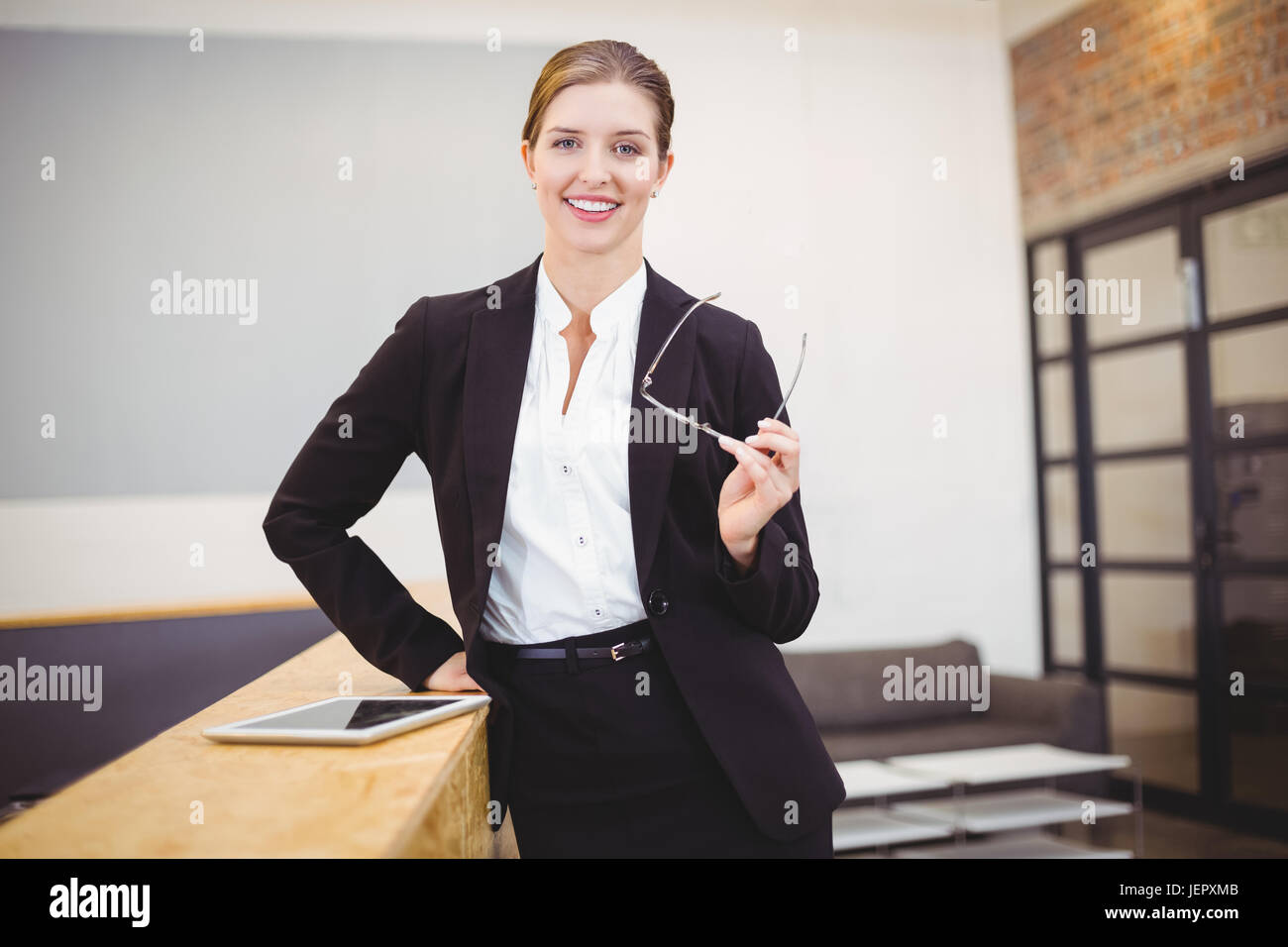 Beautiful businesswoman leaning on counter Stock Photo - Alamy