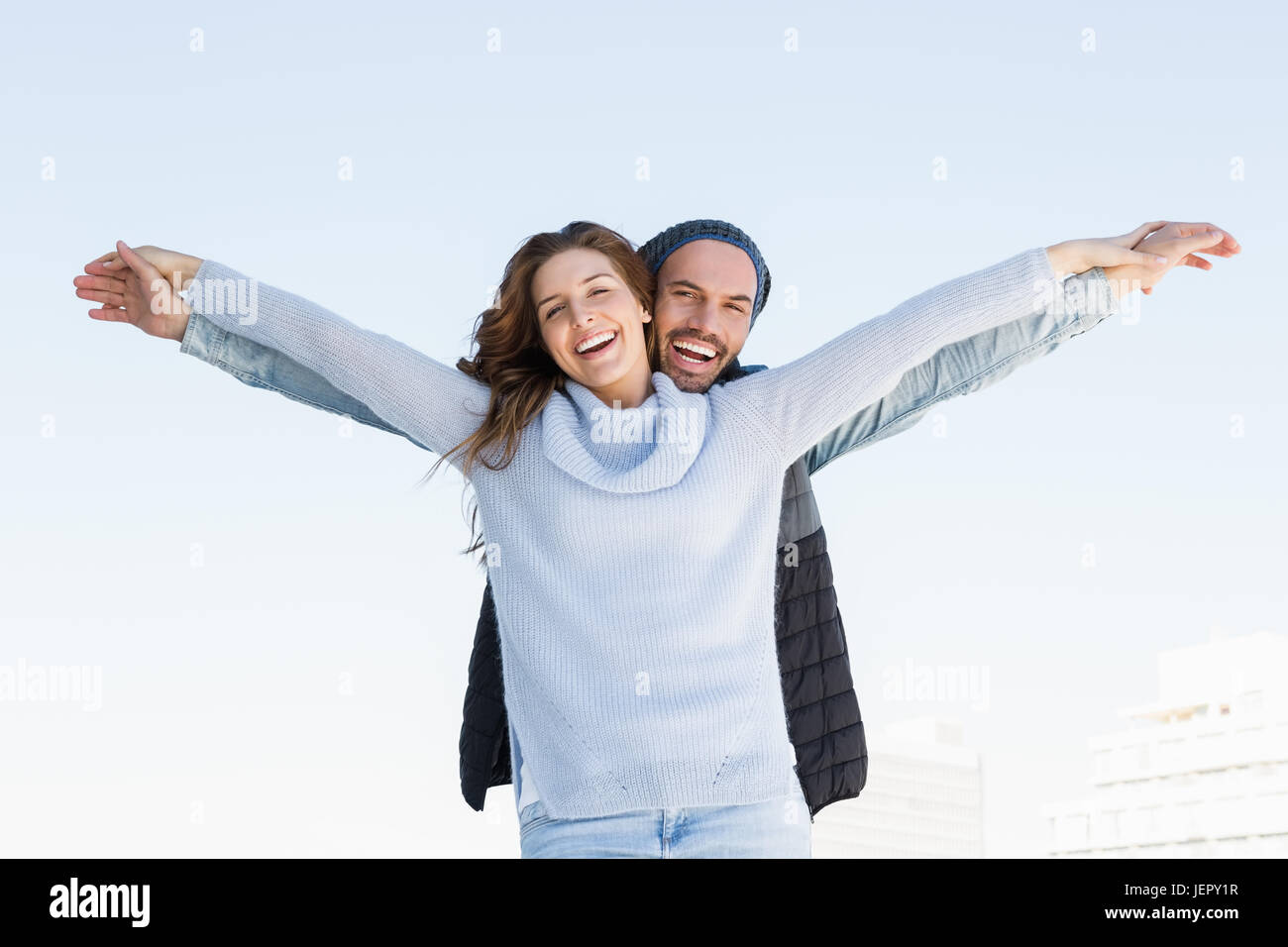 Happy couple standing with arms outstretched Stock Photo - Alamy