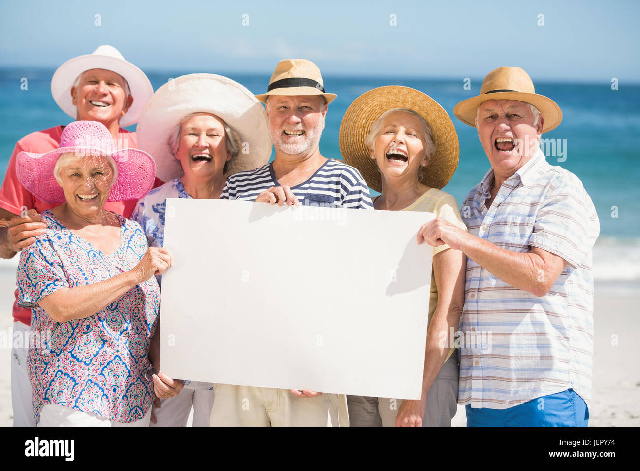 Senior friends holding blank paper Stock Photo - Alamy