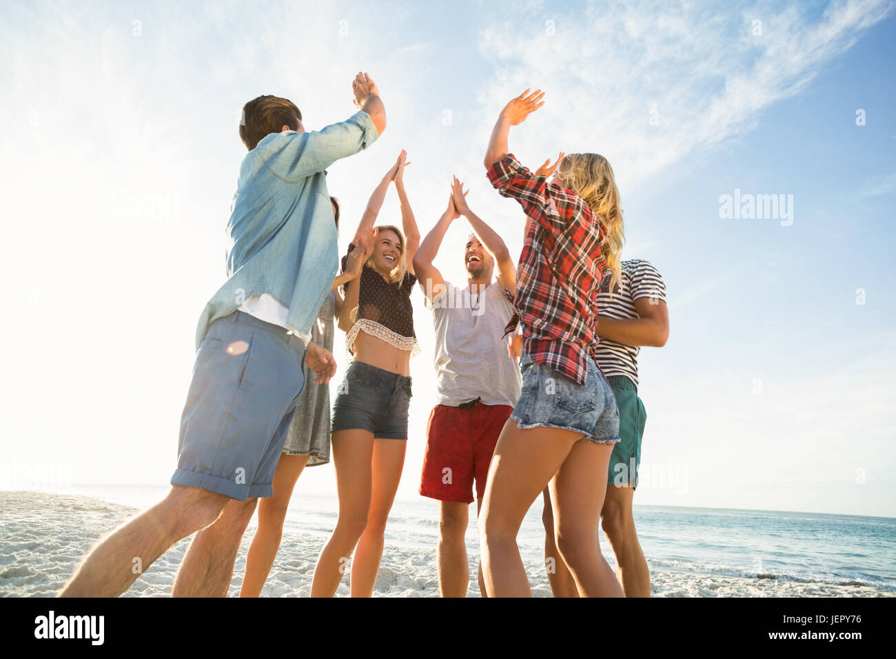 Friends doing high five on the beach Stock Photo - Alamy