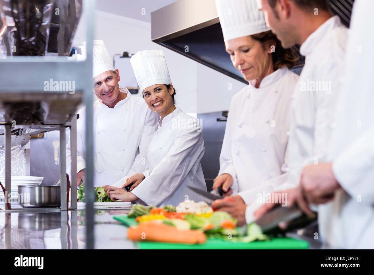 Team of chefs chopping vegetables Stock Photo - Alamy