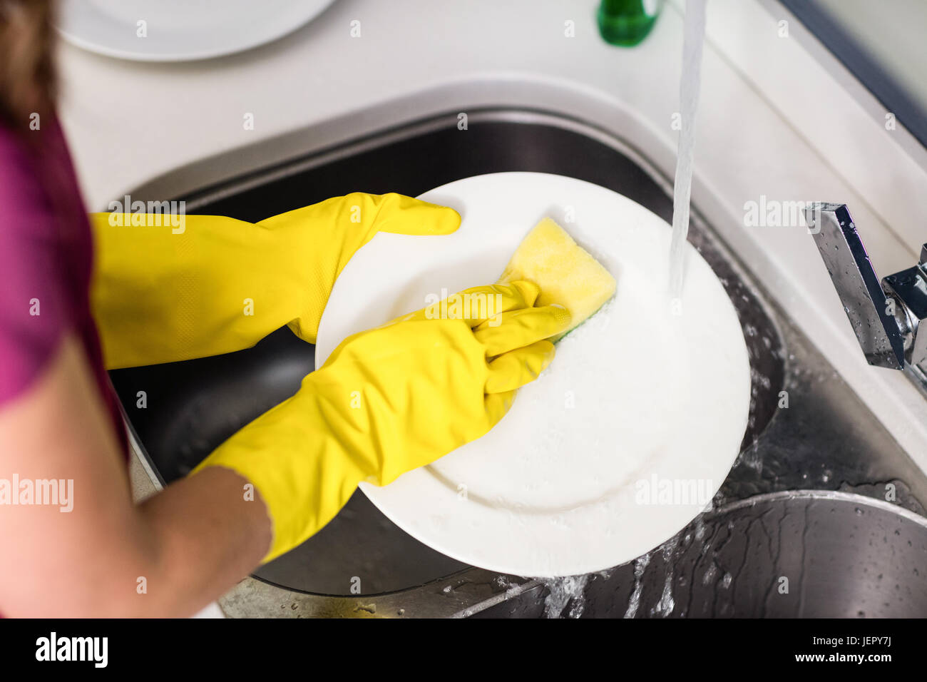 Woman washing plate at kitchen washbasin Stock Photo - Alamy