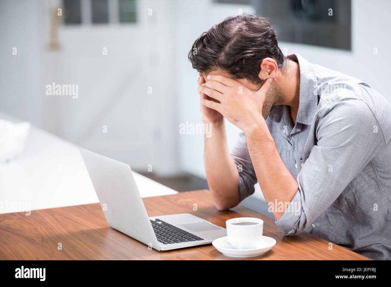 Tensed young man with head in hands Stock Photo - Alamy