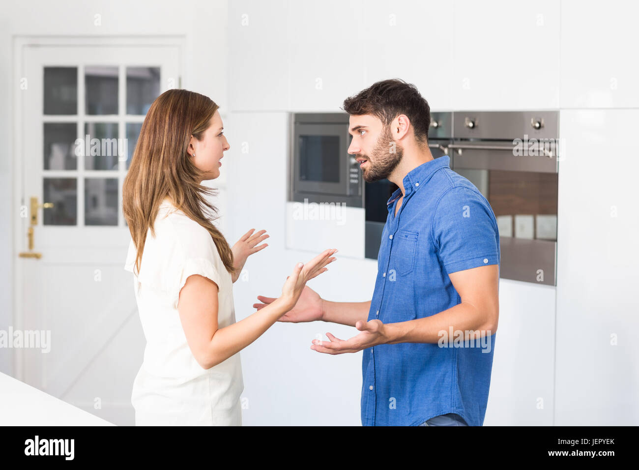 Couple arguing while standing in kitchen Stock Photo - Alamy