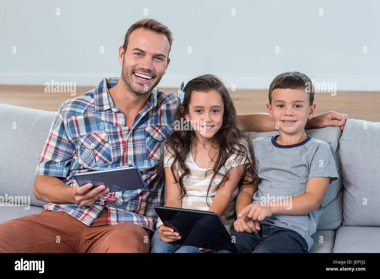 Father and siblings using digital tablet Stock Photo - Alamy