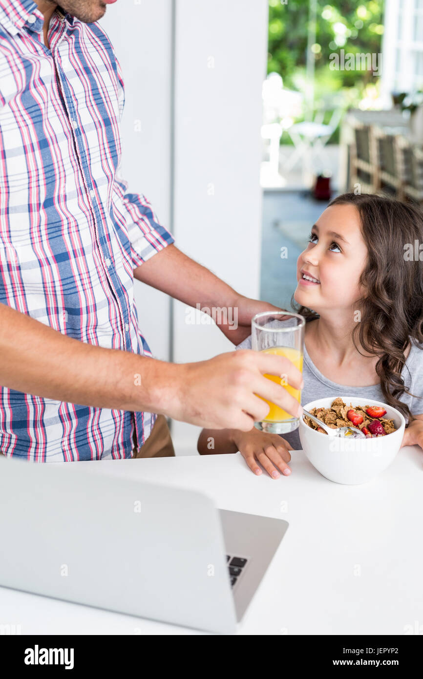 Father giving juice to daughter Stock Photo - Alamy