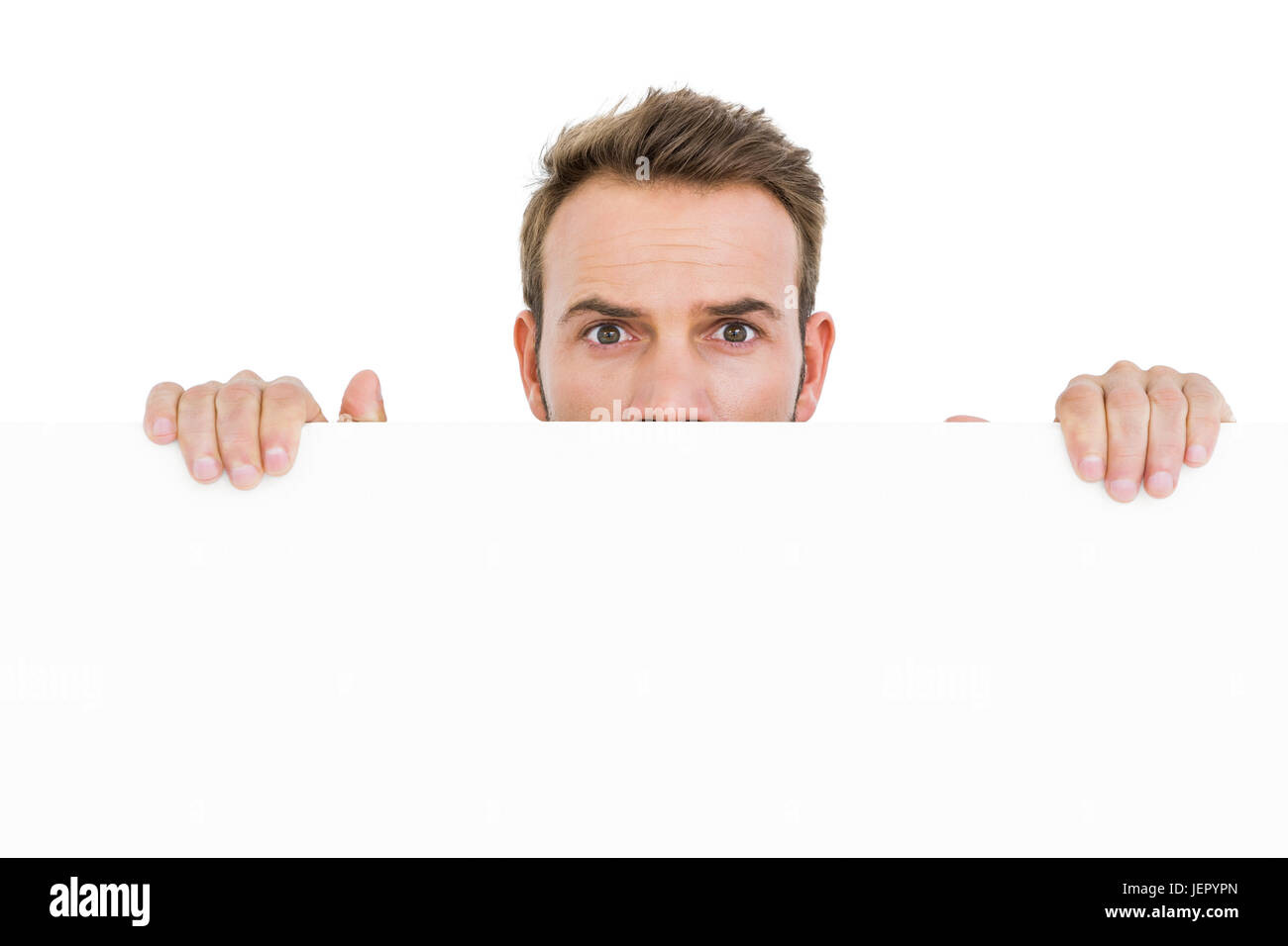 Young man hiding behind white board Stock Photo - Alamy
