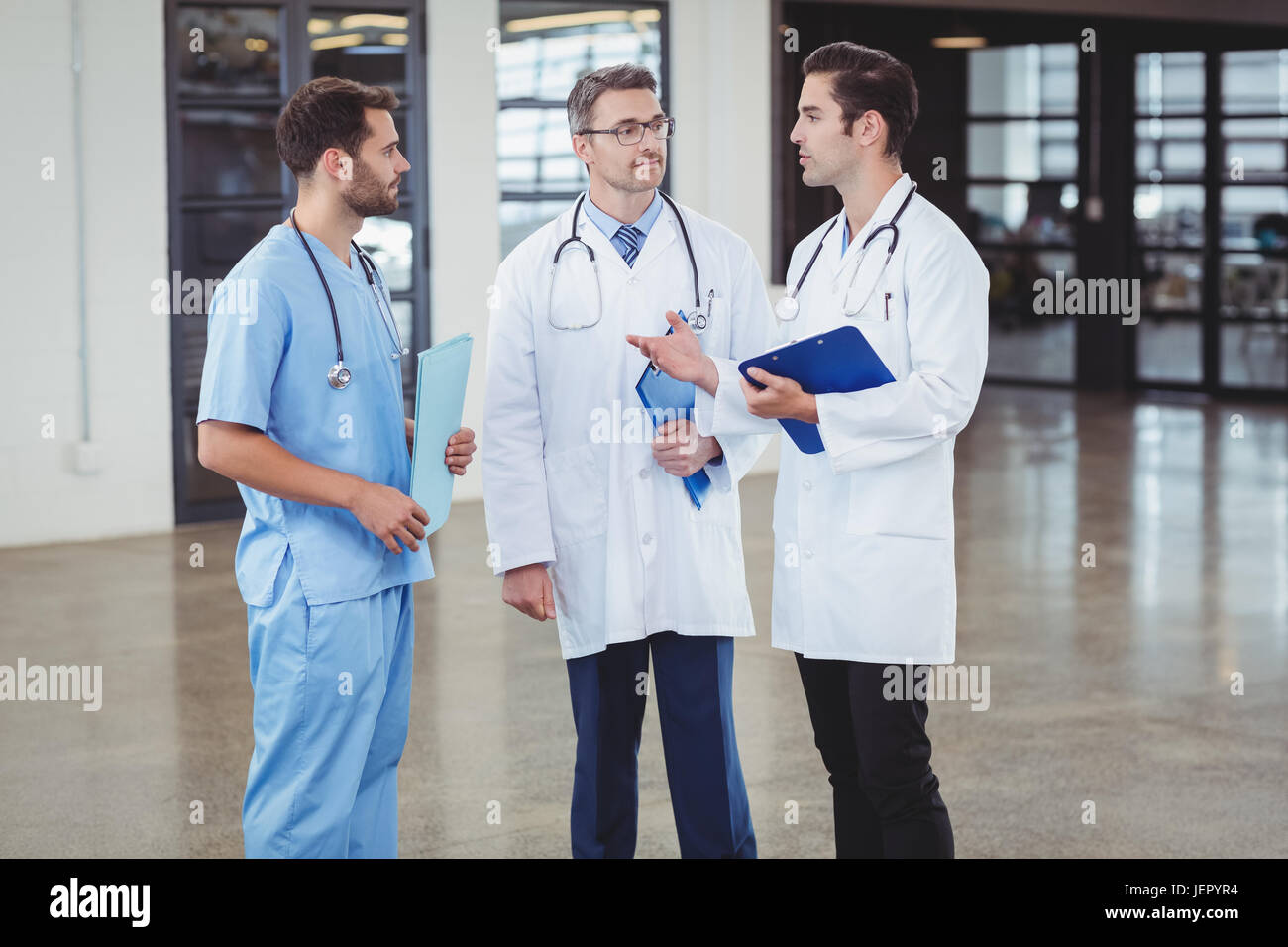 Doctors discussing while standing Stock Photo - Alamy