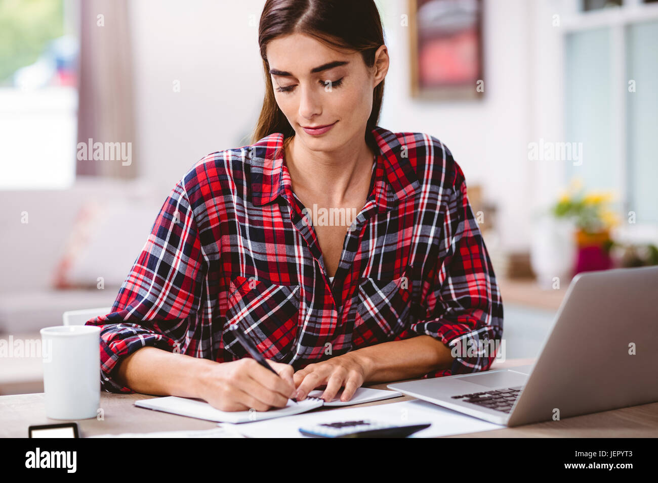 Young woman writing in notepad Stock Photo - Alamy