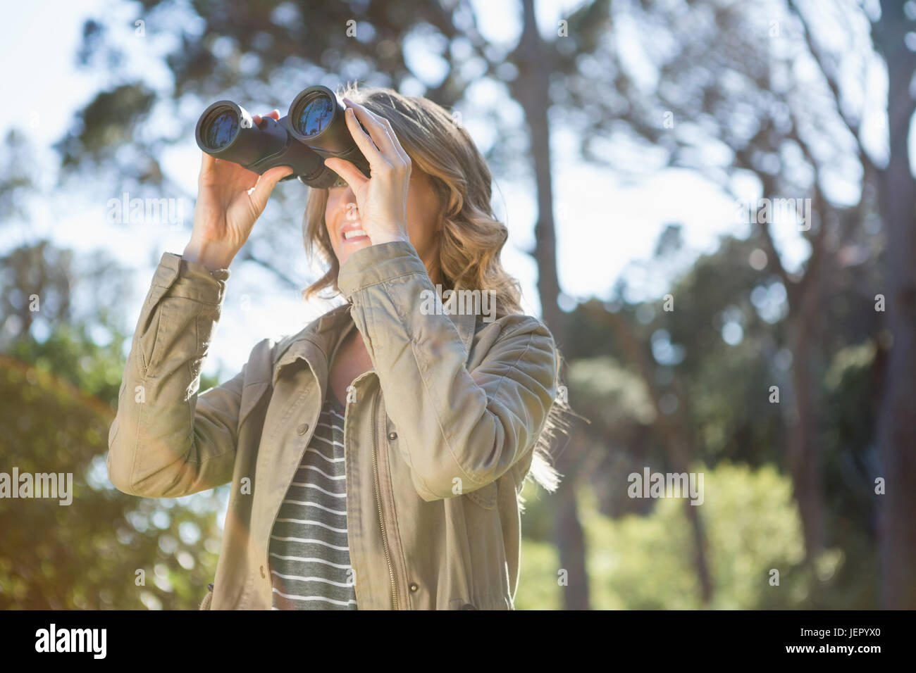 Woman using binoculars Stock Photo - Alamy