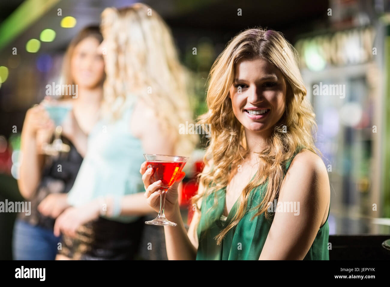 Blonde woman drinking cocktail Stock Photo - Alamy