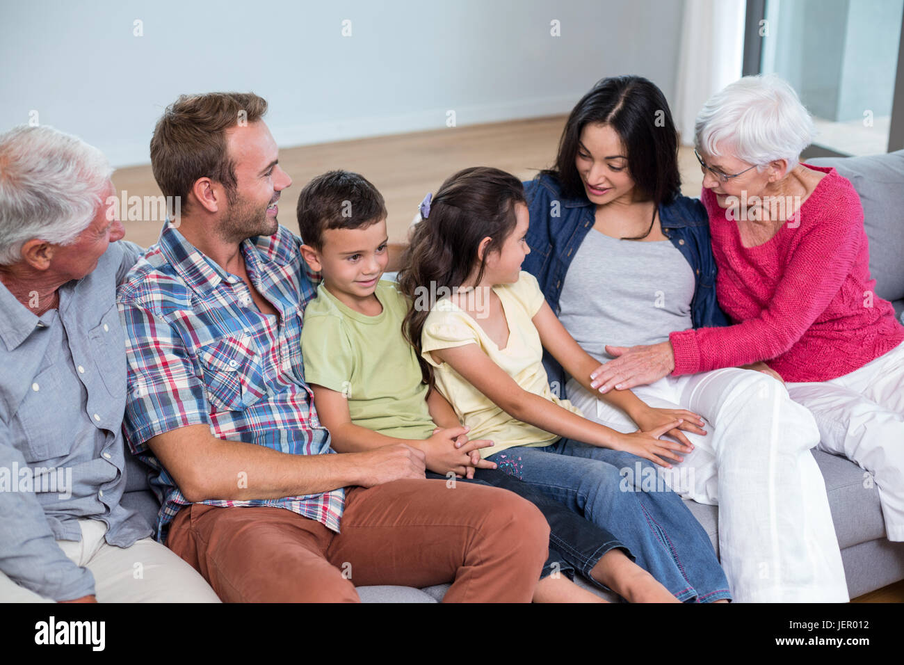 Family sitting on sofa Stock Photo - Alamy