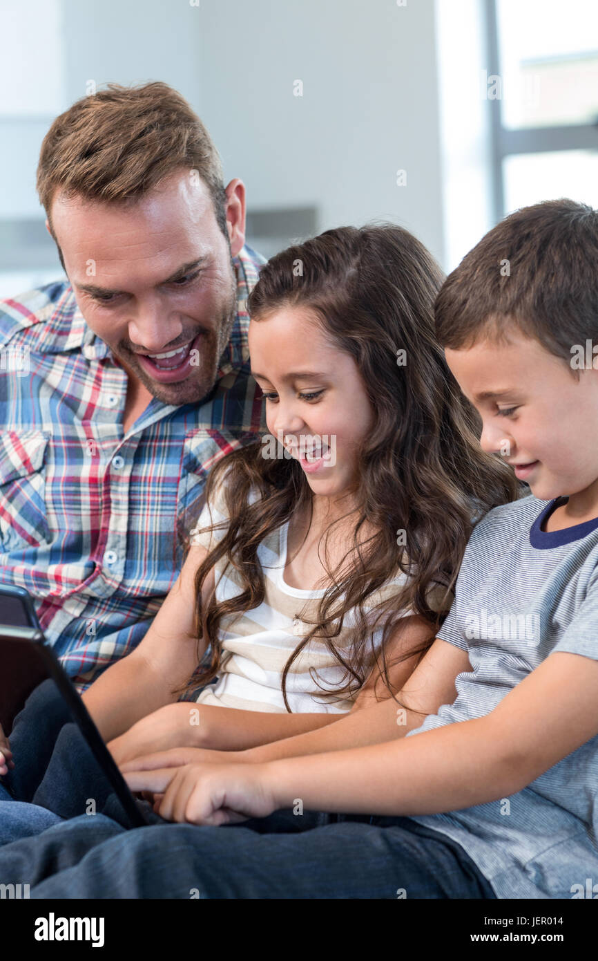 Father and siblings using digital tablet Stock Photo - Alamy