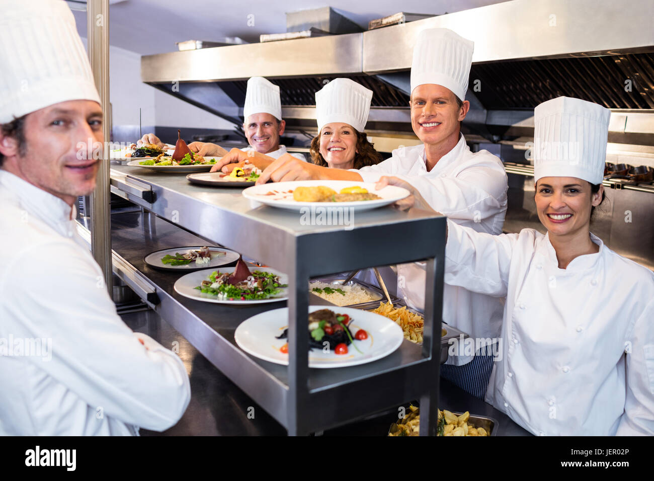 Portrait of chef team smiling Stock Photo - Alamy