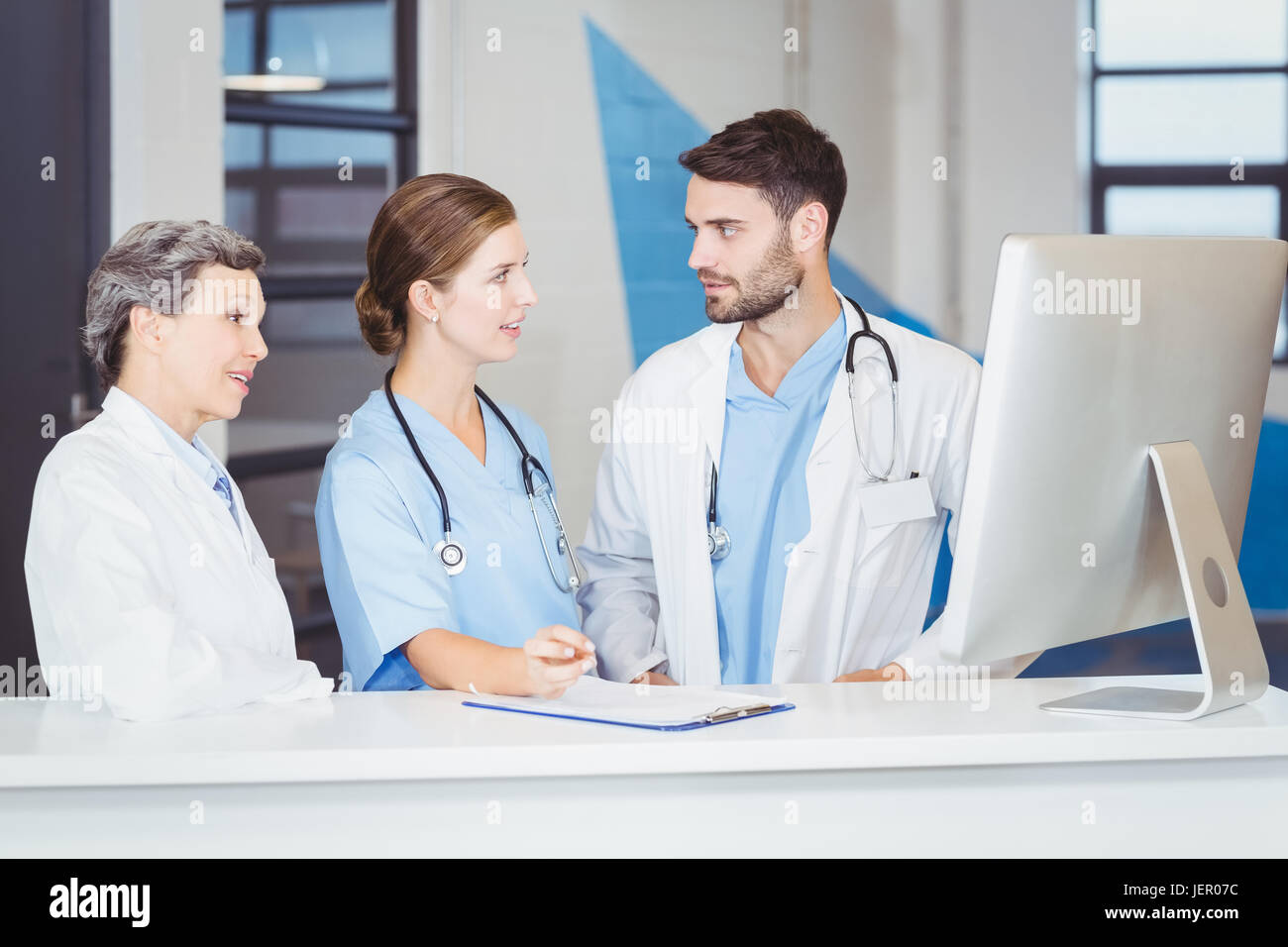 Doctors discussing at computer desk Stock Photo - Alamy