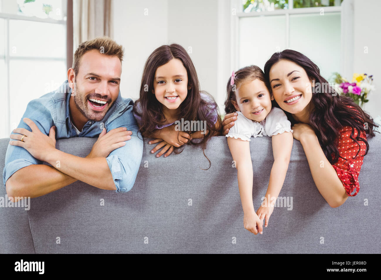 Happy family relaxing on sofa at home Stock Photo - Alamy