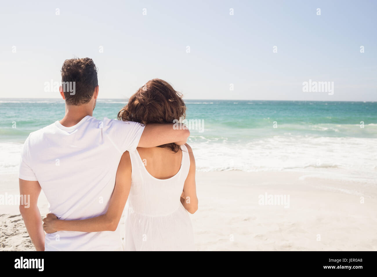 Young couple looking at the beach Stock Photo - Alamy