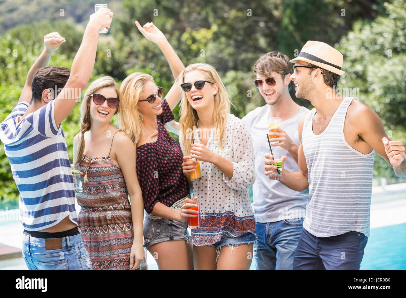 Group of friends dancing near pool Stock Photo - Alamy