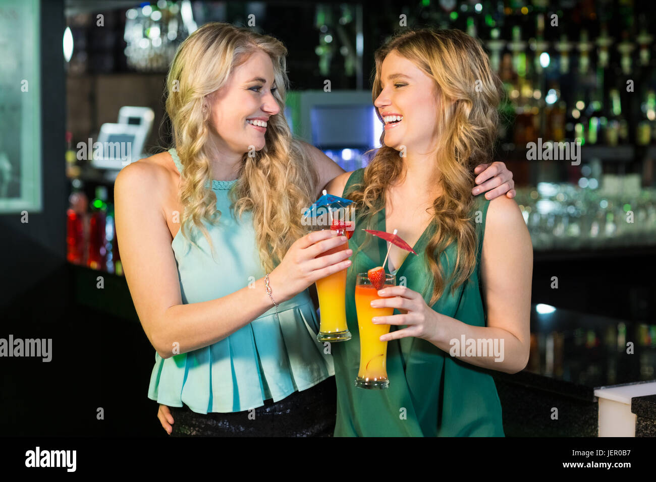 Happy friends drinking cocktails Stock Photo - Alamy