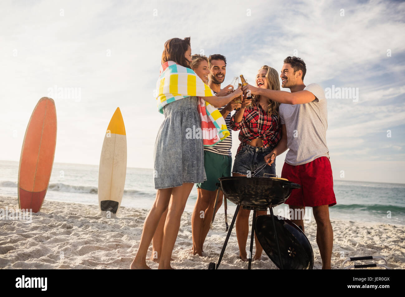 Happy friends having fun around barbecue Stock Photo - Alamy
