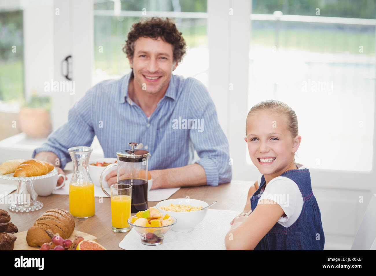Girl having breakfast with father Stock Photo - Alamy