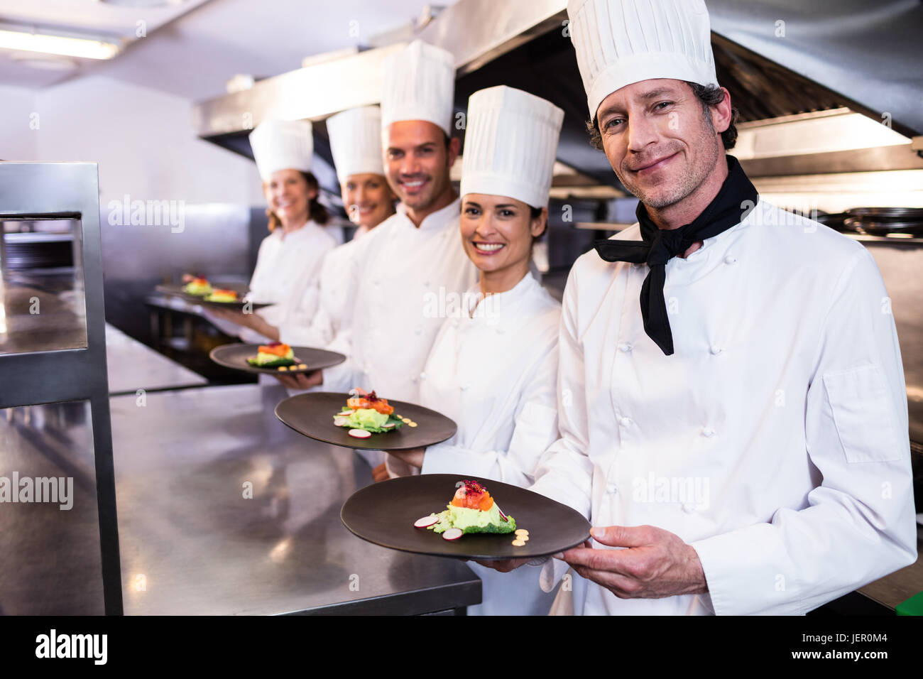 Happy chefs presenting their food plates Stock Photo - Alamy