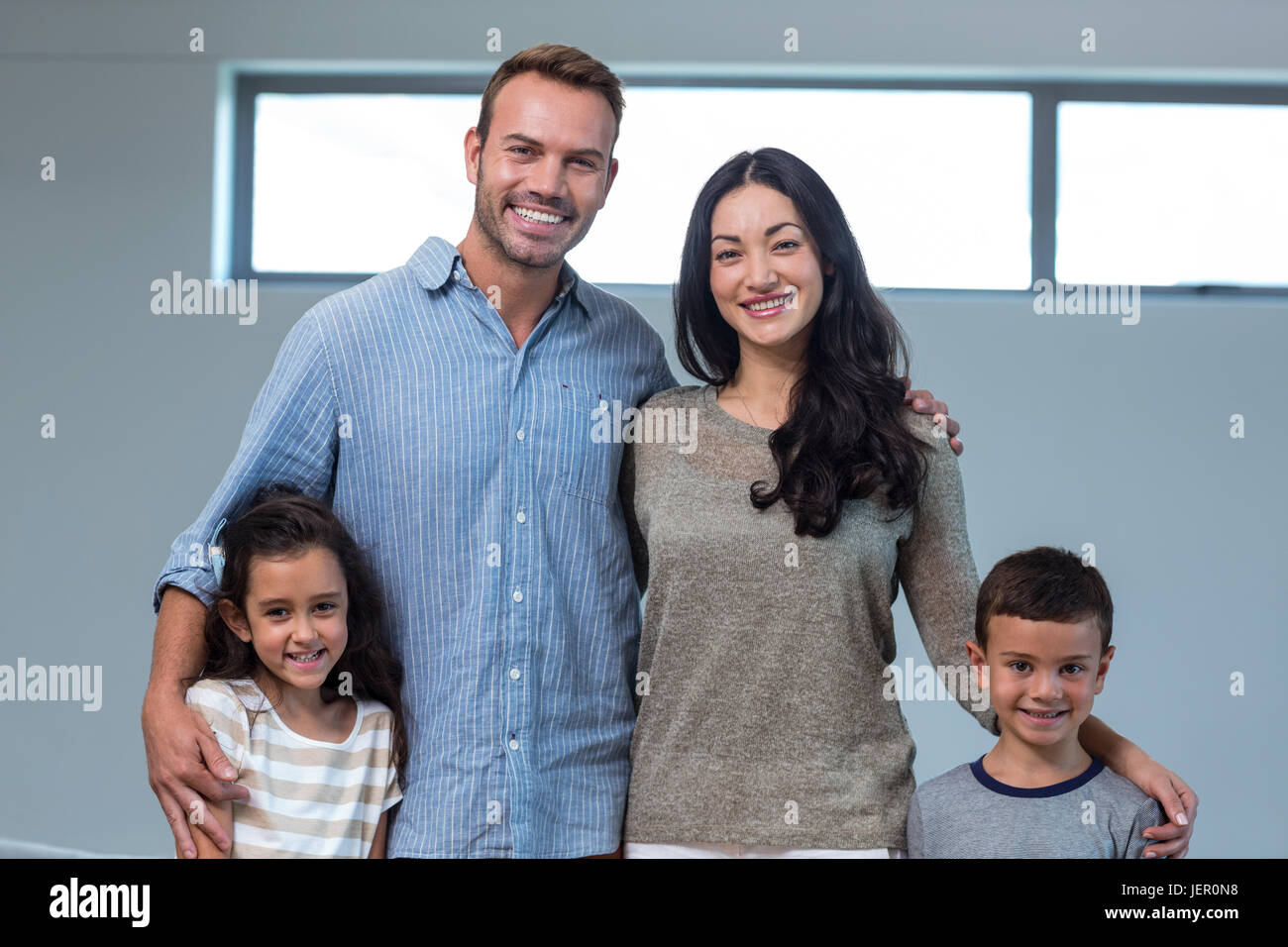 Family standing together and smiling Stock Photo - Alamy