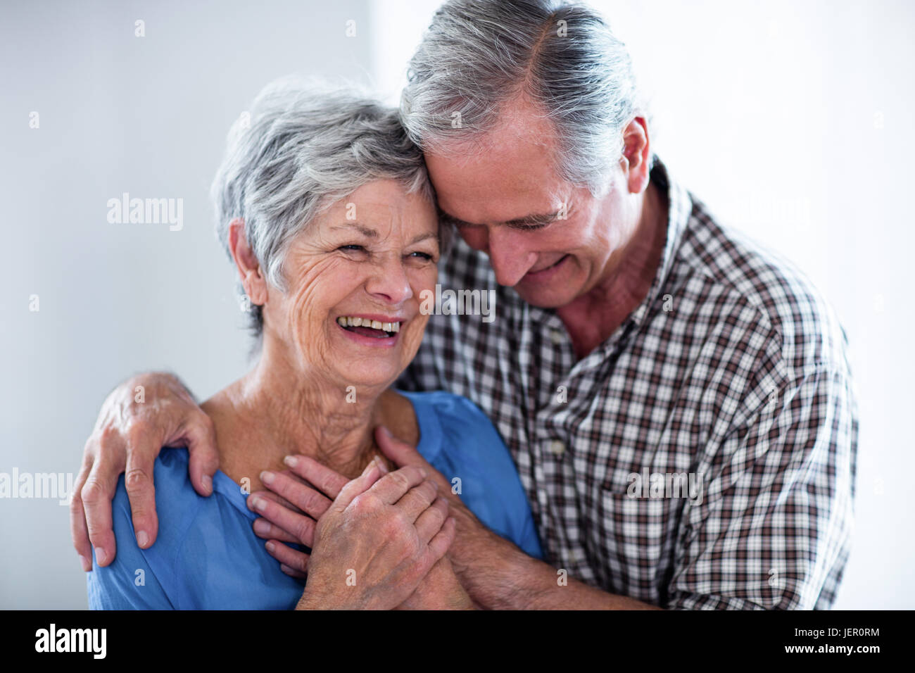Happy senior couple smiling while embracing Stock Photo - Alamy