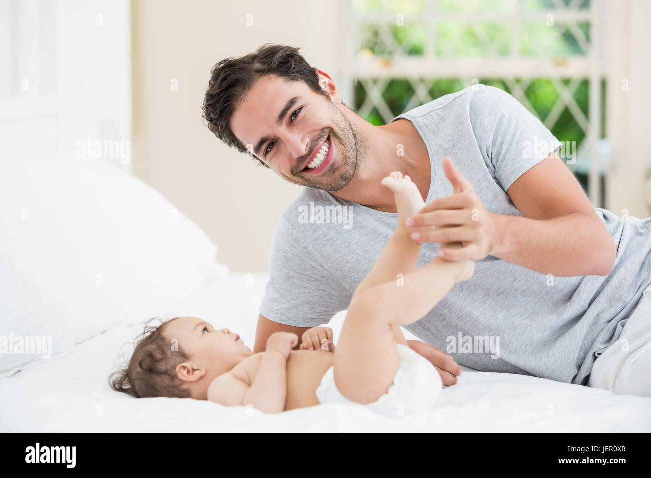 Portrait of smiling father playing with baby Stock Photo - Alamy