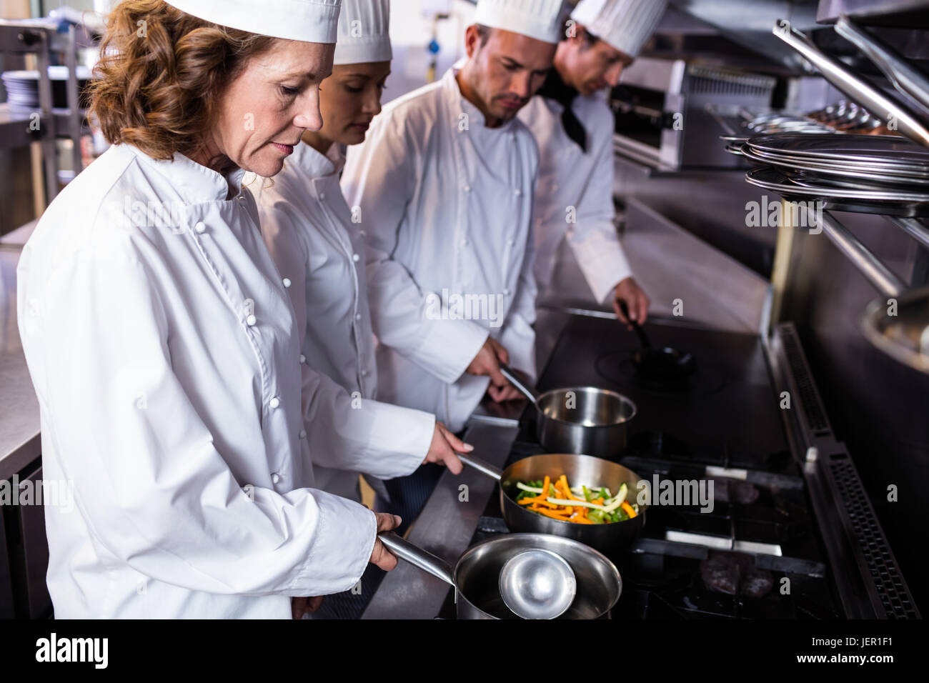 Chefs preparing food in kitchen Stock Photo - Alamy