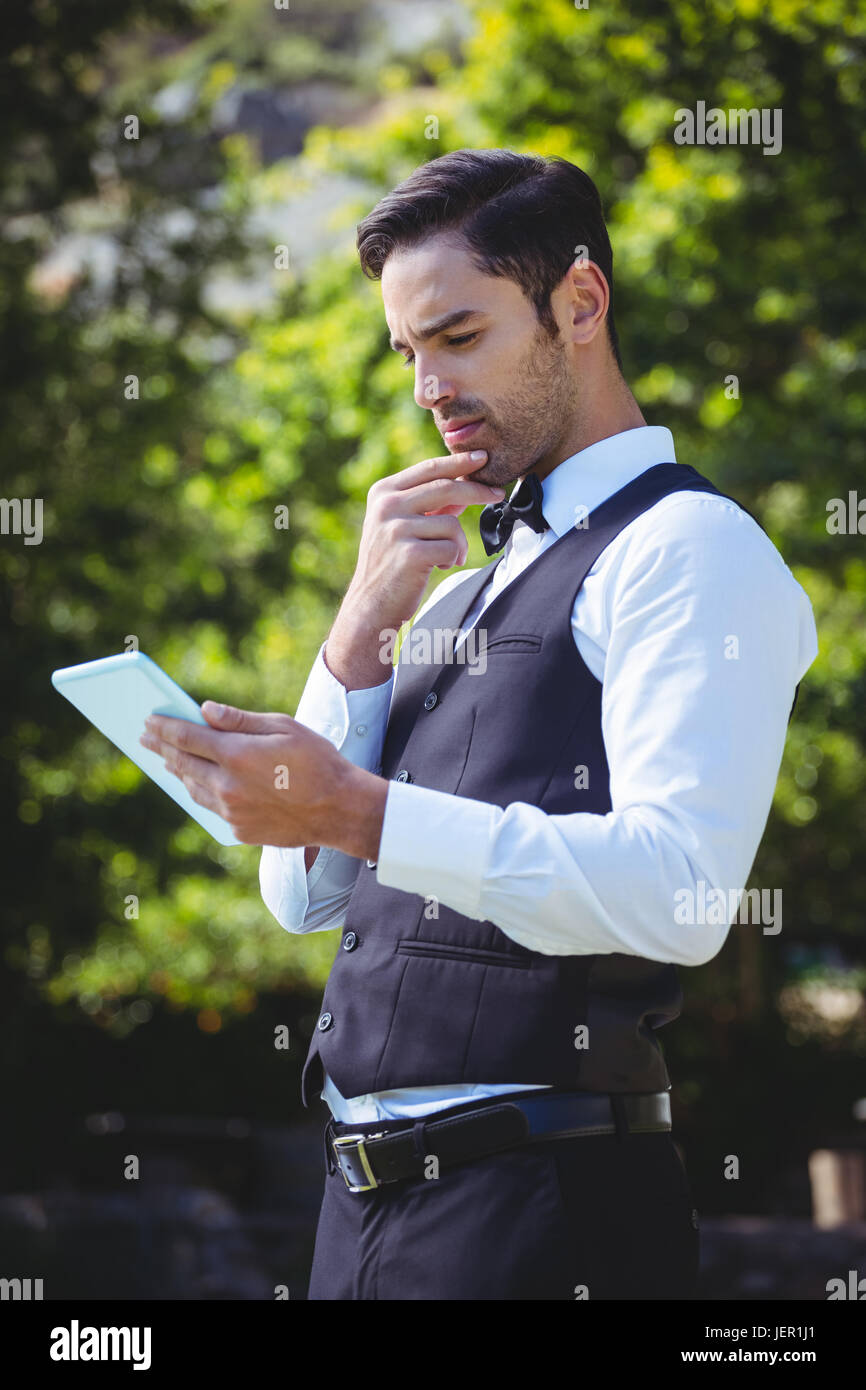 Handsome waiter using tablet computer Stock Photo - Alamy
