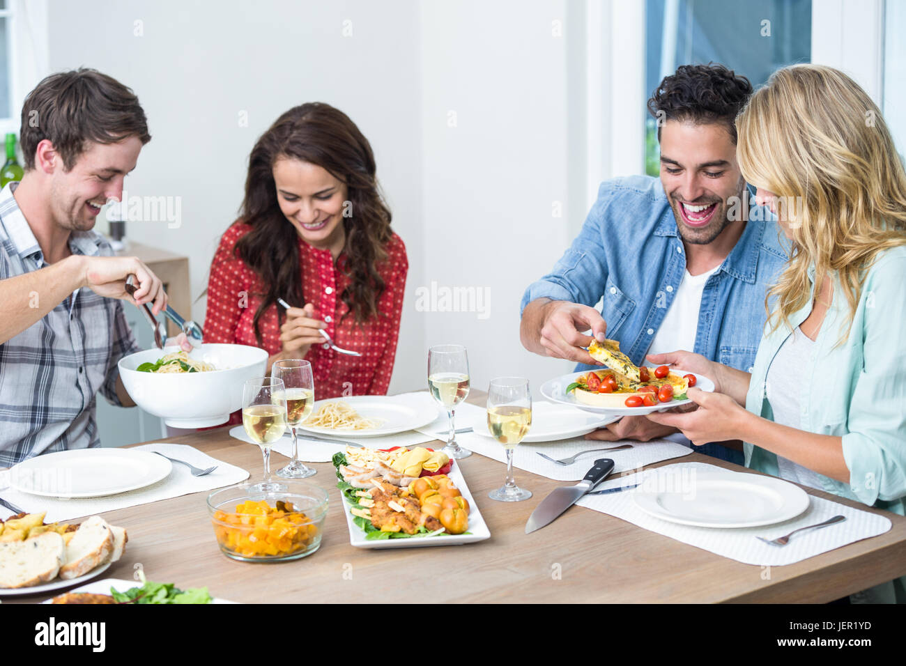 Smiling friends having food Stock Photo - Alamy