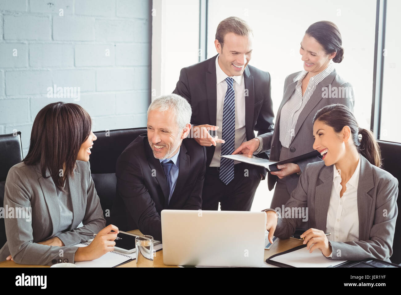 Businesspeople interacting in conference room Stock Photo - Alamy